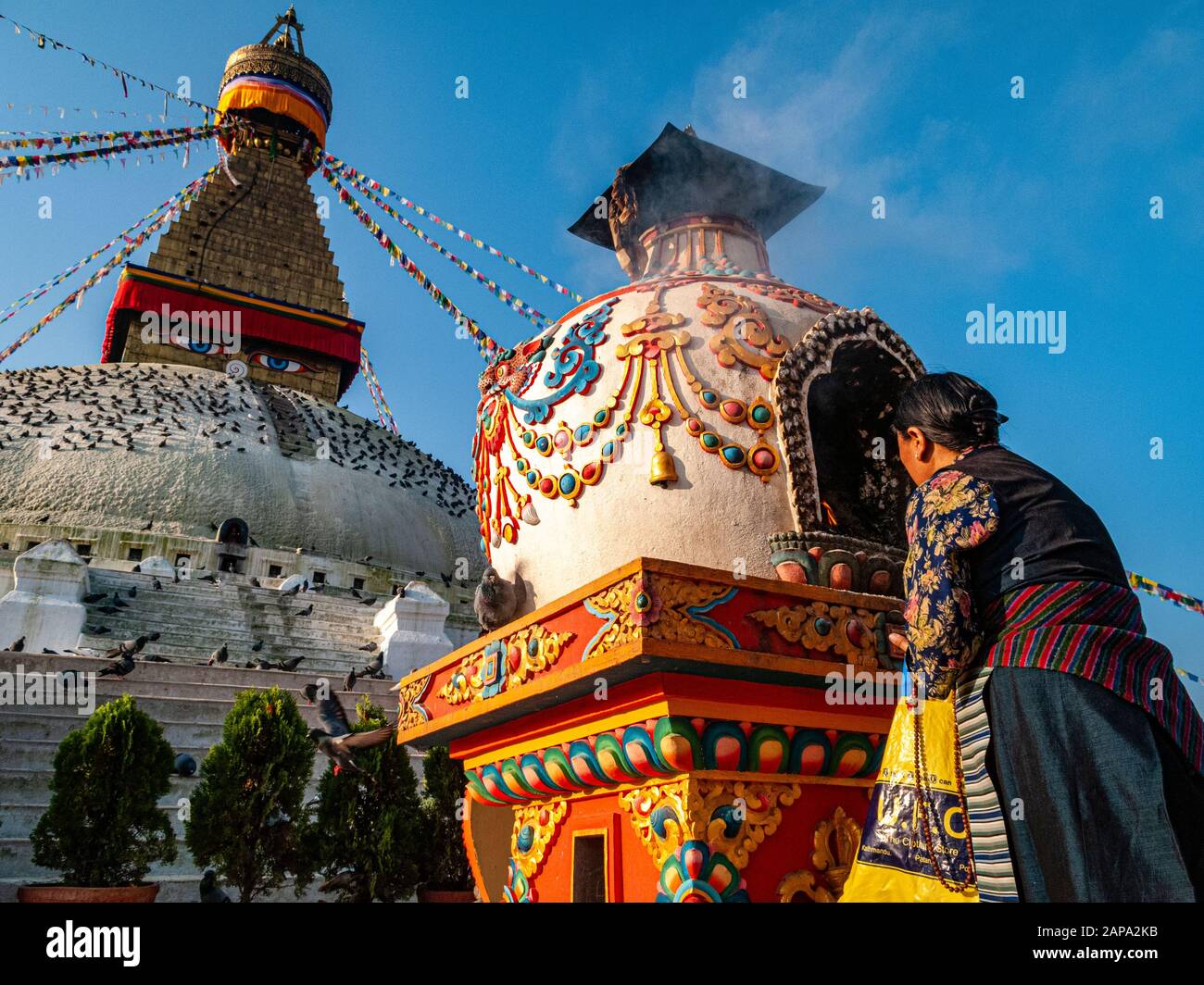 An old woman is performing a religious ceremony at Boudha Stupa Stock ...