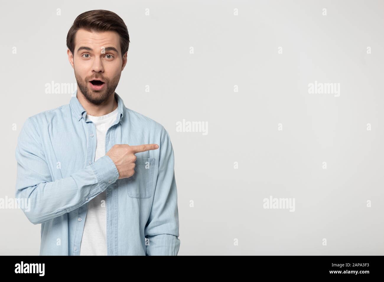 Excited young man standing aside, pointing at empty copy space Stock ...