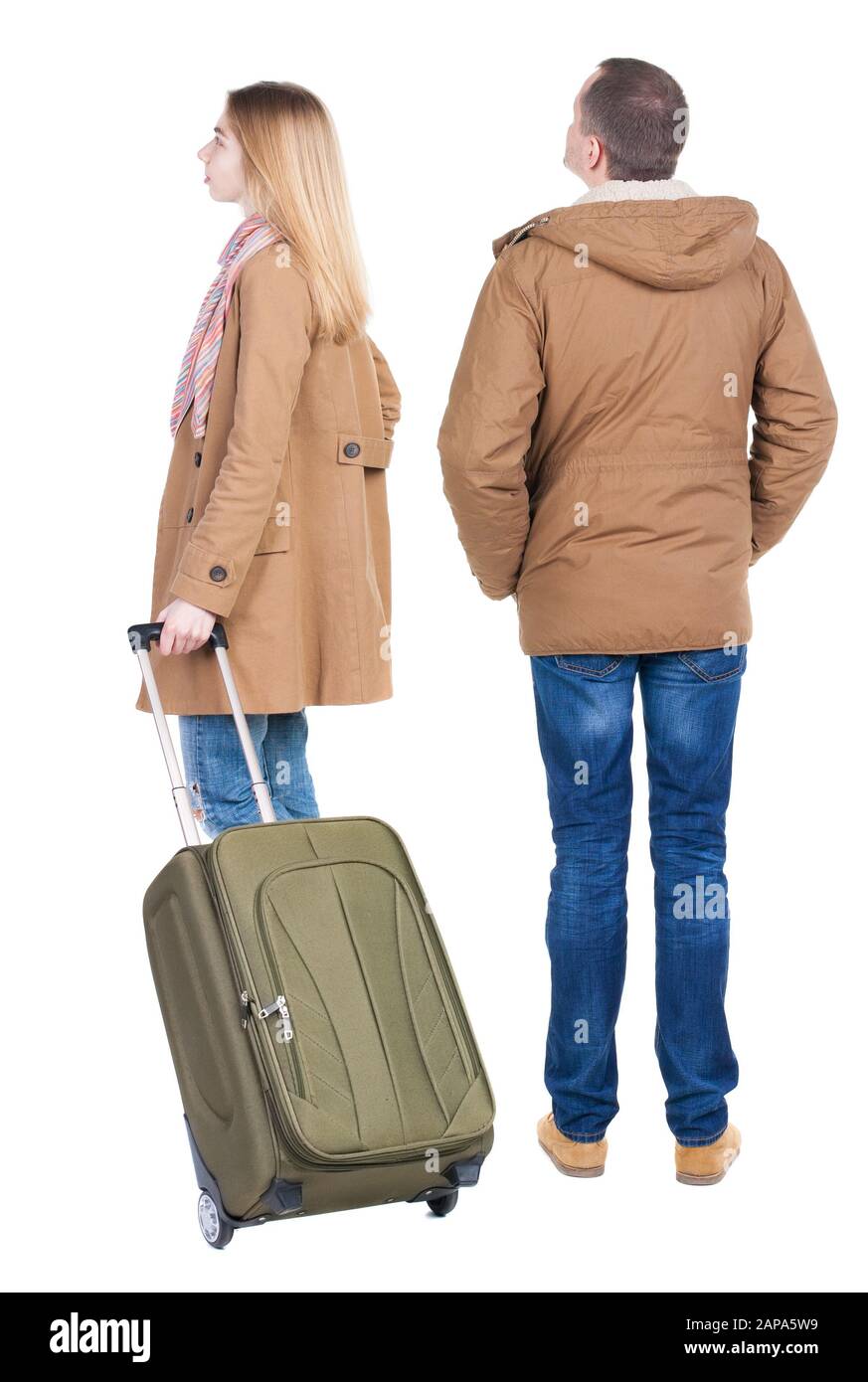 young couple in winter jacket traveling with suitcas. Back view. Rear ...