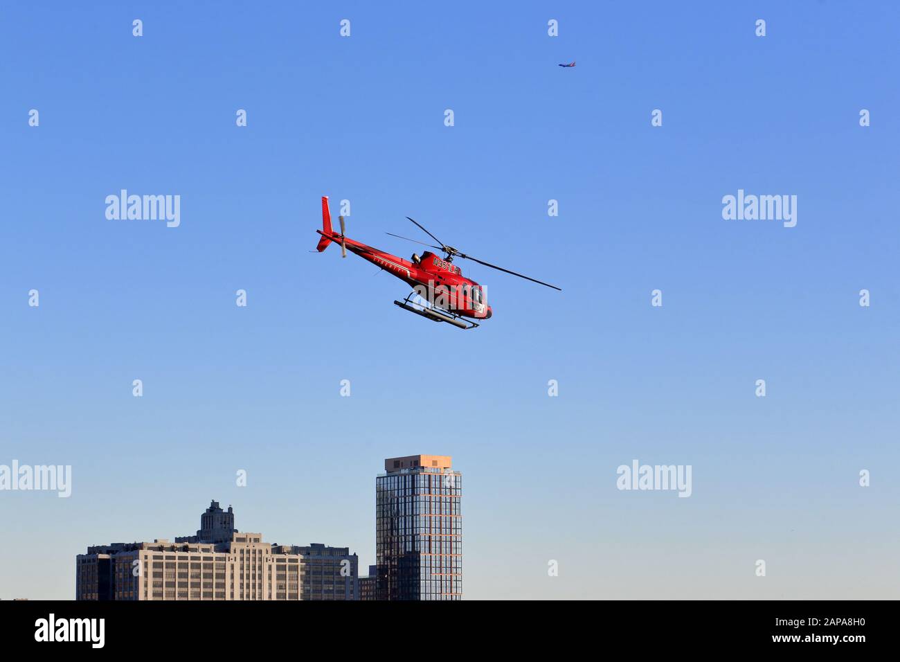 A red helicopter flying above two buildings in Brooklyn, New York, NY ...