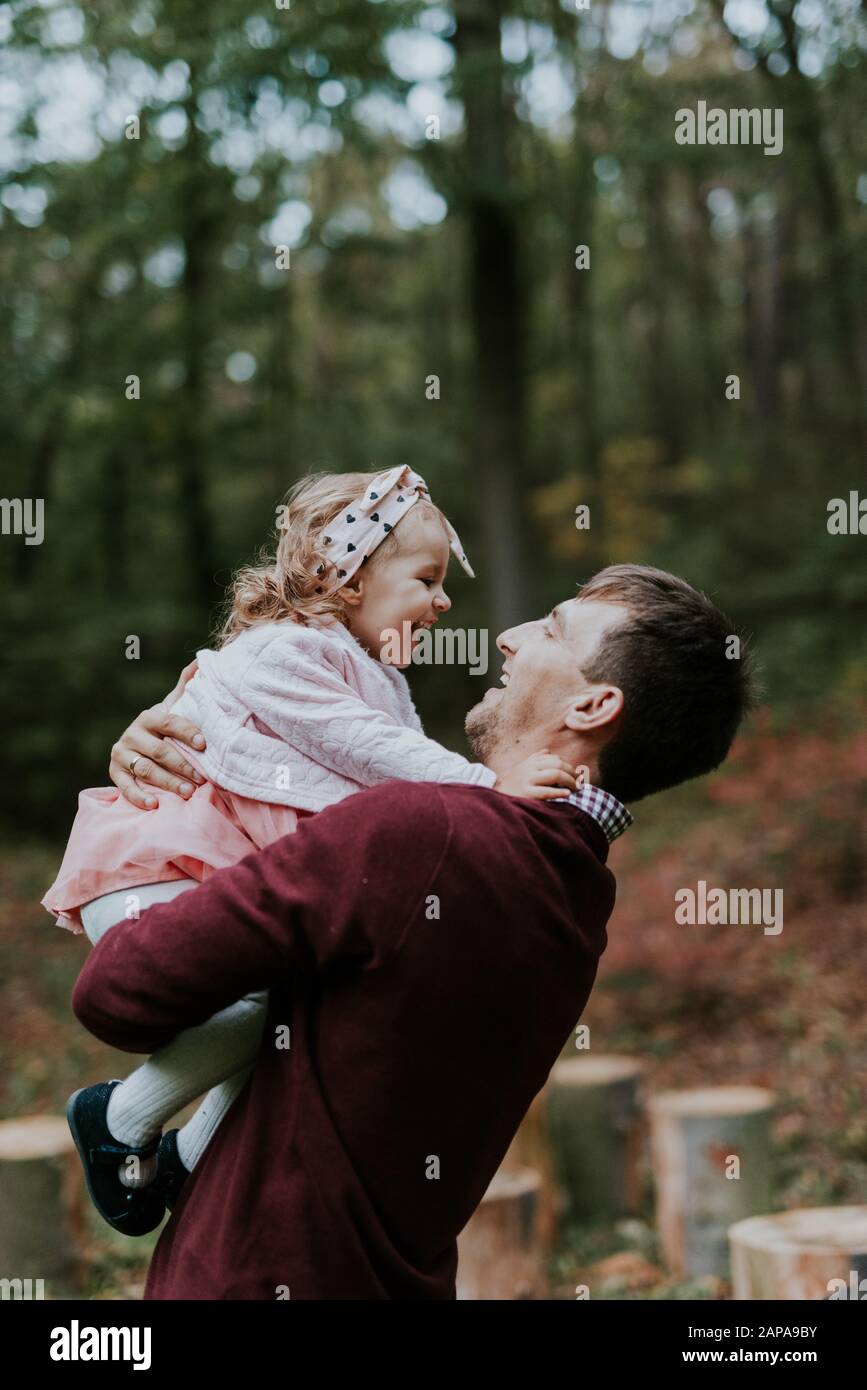 Little daughter riding father on shoulders Stock Photo - Alamy