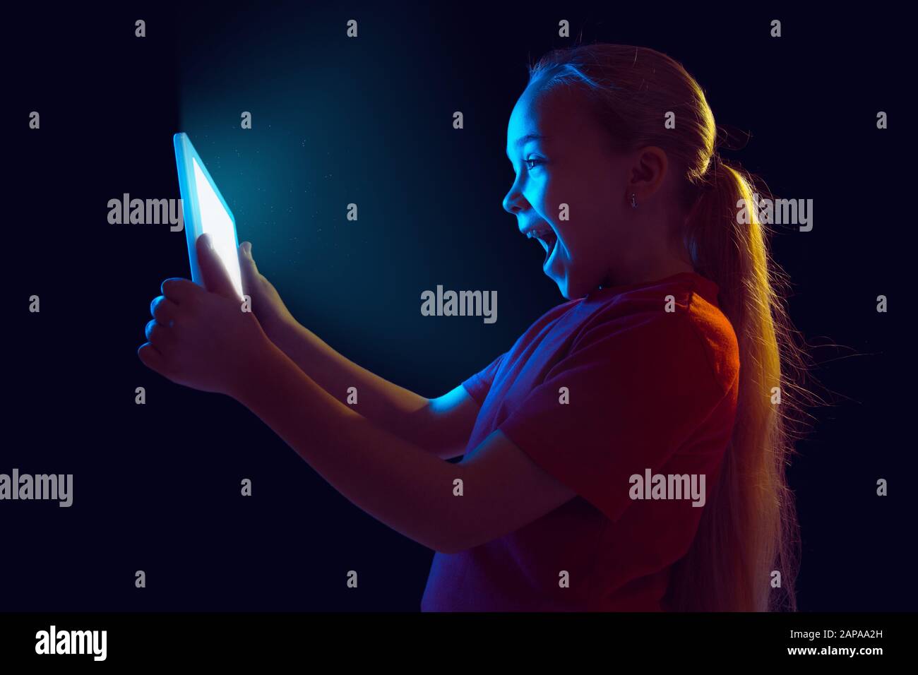 Playing expressive. Caucasian girl's portrait on dark studio background ...