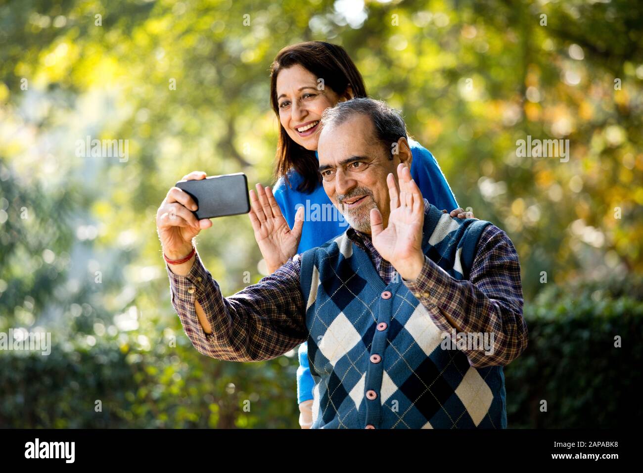 Senior woman sharing media content with her husband using mobile phone ...