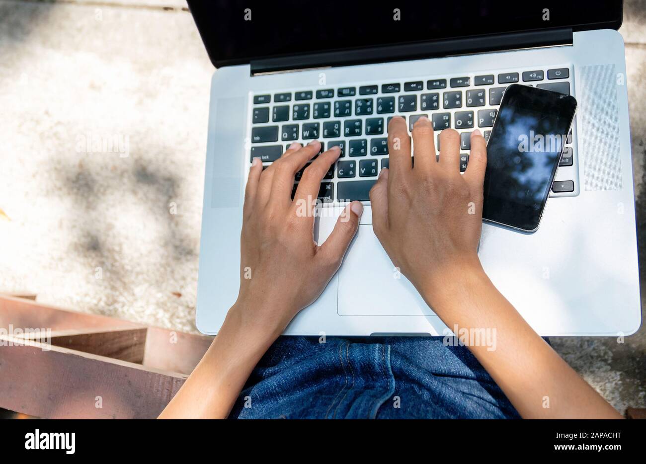 Two hands on the keyboard of computer with the black mobile phone Stock ...