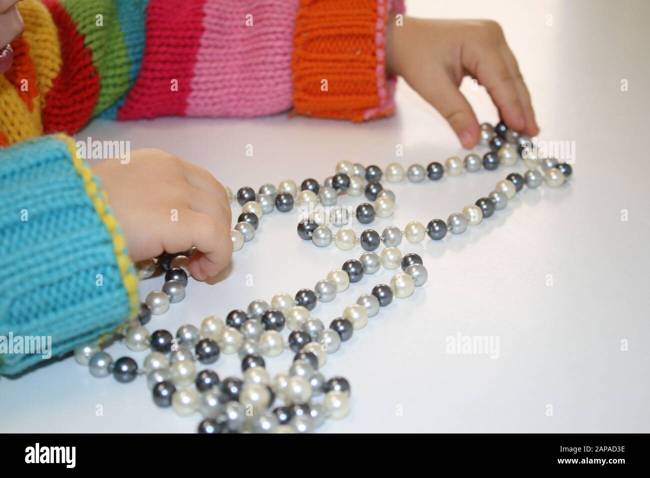 Necklace on a white background, which is played by the child ...