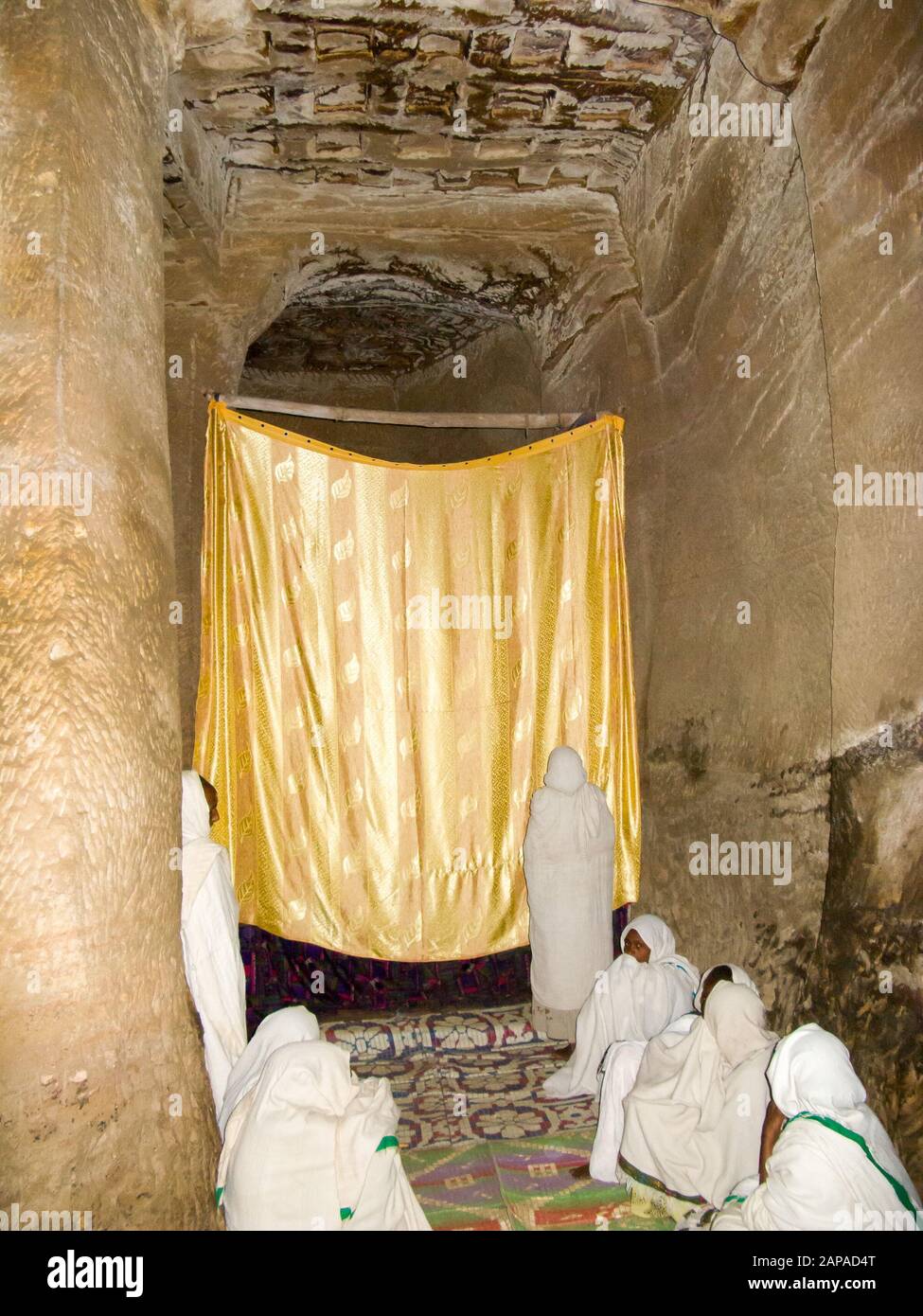 Ethiopian women sitting inside Medhane Alem Adi Kasho rock hewn church ...