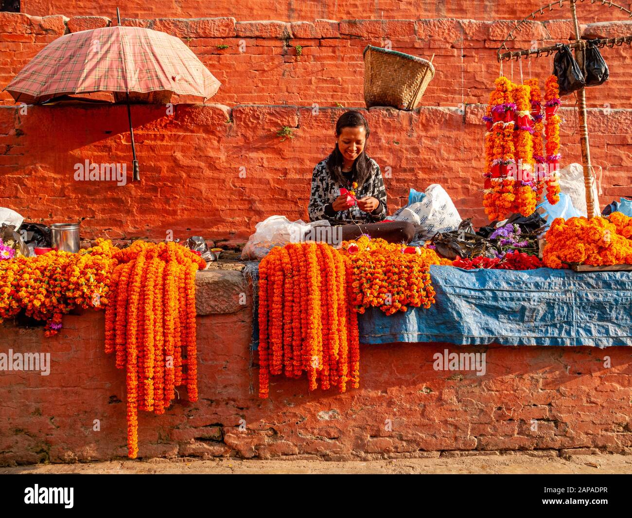 Local Woman producing and selling flowers for religious rituals in the ...