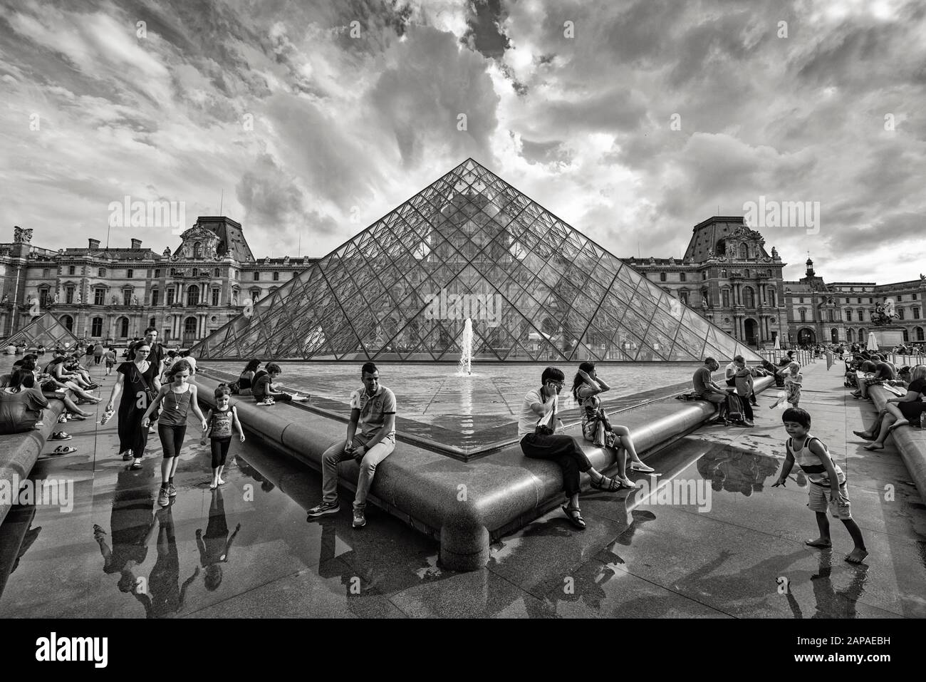 People sitting by the fountains outside the Louvre Museum Stock Photo ...