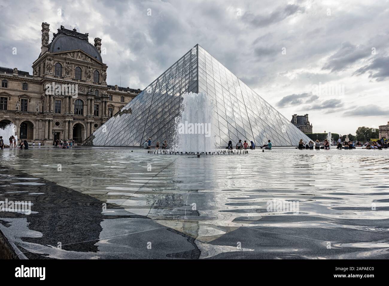 People sitting by the fountains outside the Louvre Museum Stock Photo ...