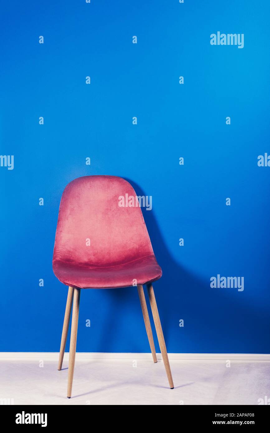 Modern Pink Velour Chair on wooden legs, blue background Stock Photo ...