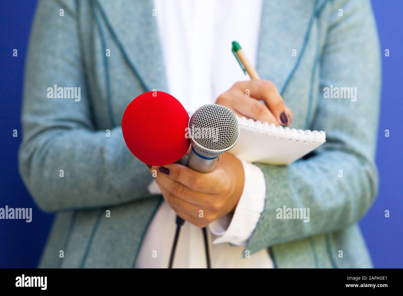 Reporter at news conference, taking notes, holding microphone Stock ...