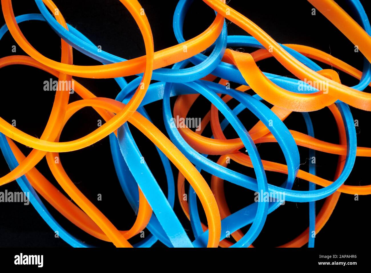 pile of colorful small rubber bands isolated on a black back ground ...