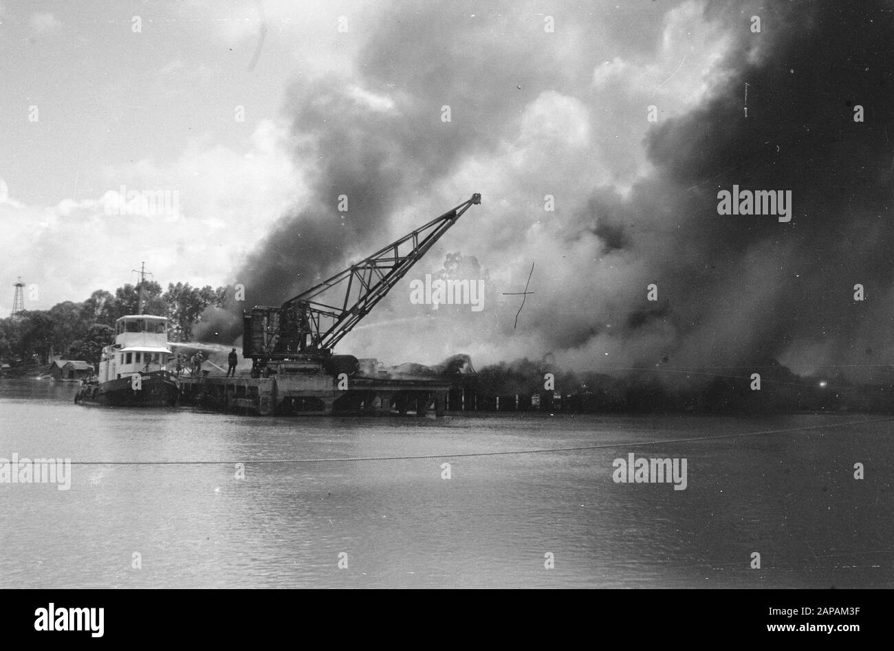 Djambi Description: Quenching a fire on a jetty in the river. At the ...