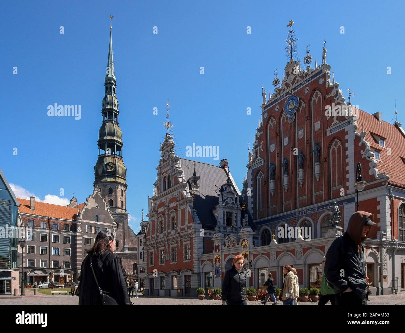 Spring day blue sky in the old town of Riga with people walking across ...