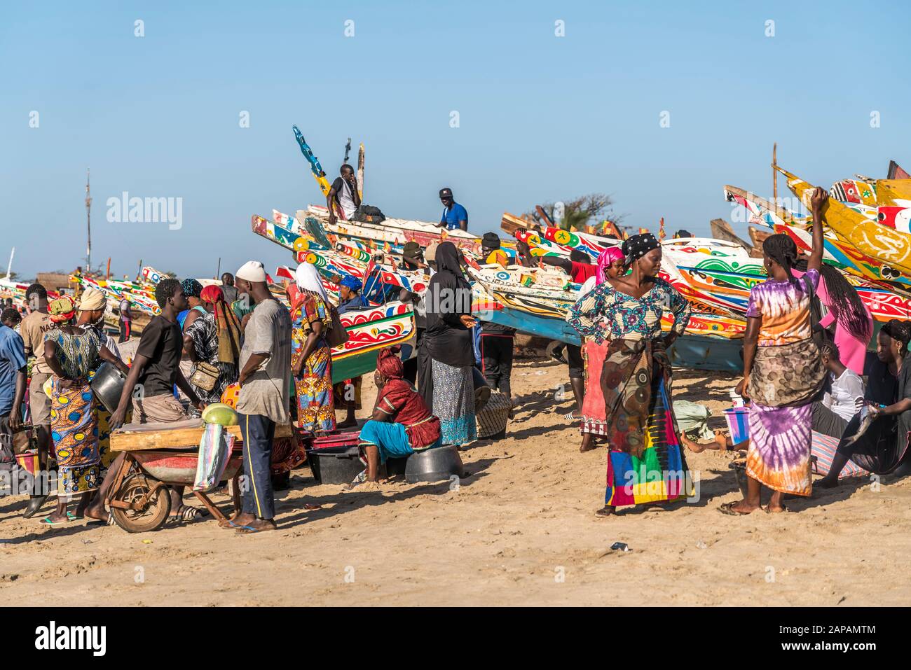 Bunte Kleider und Boote auf dem Fischmarkt in Tanji, Gambia, Westafrika ...