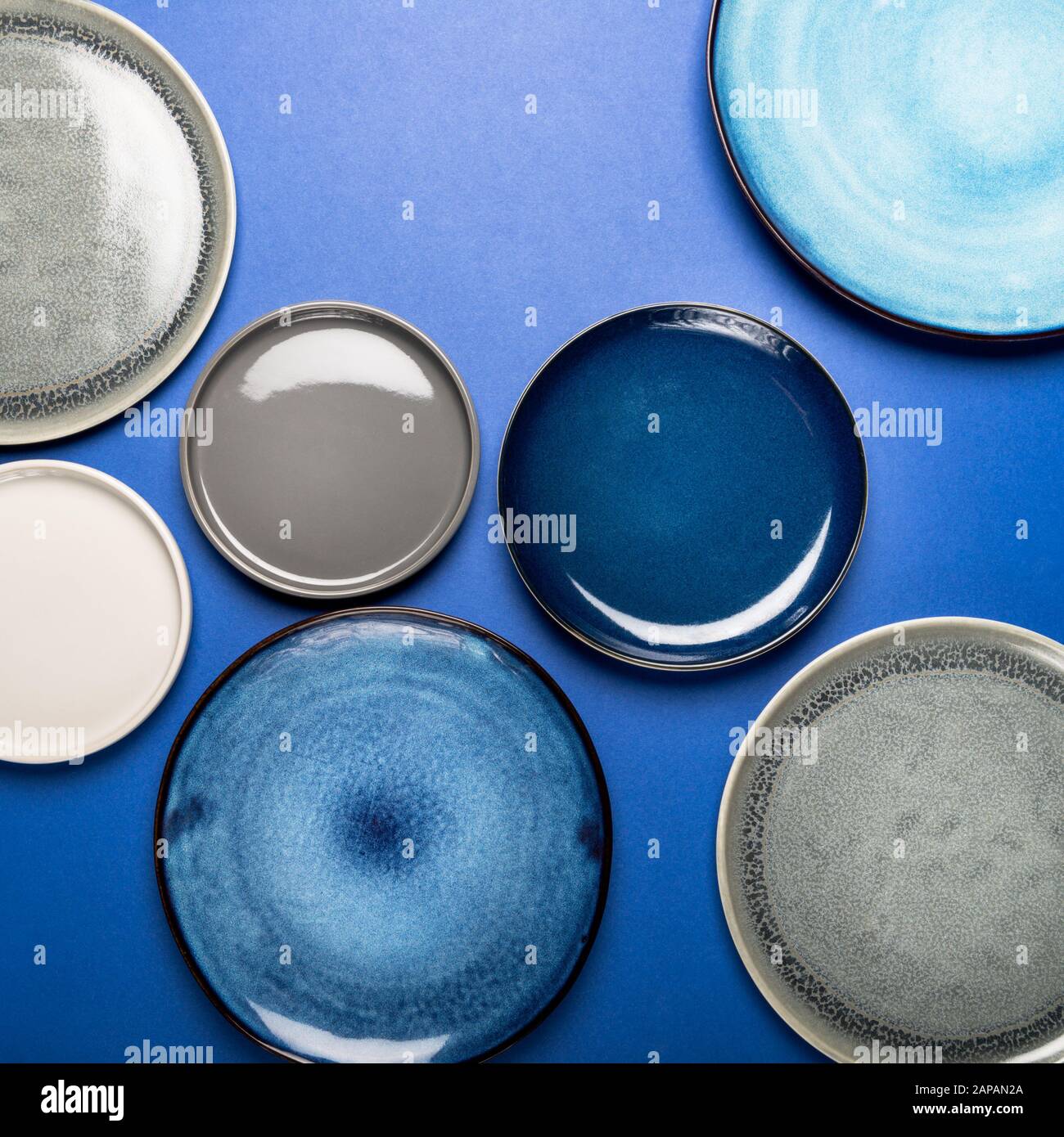 Different Ceramic Empty Blue and Grey Plates on Blue Background, Top ...