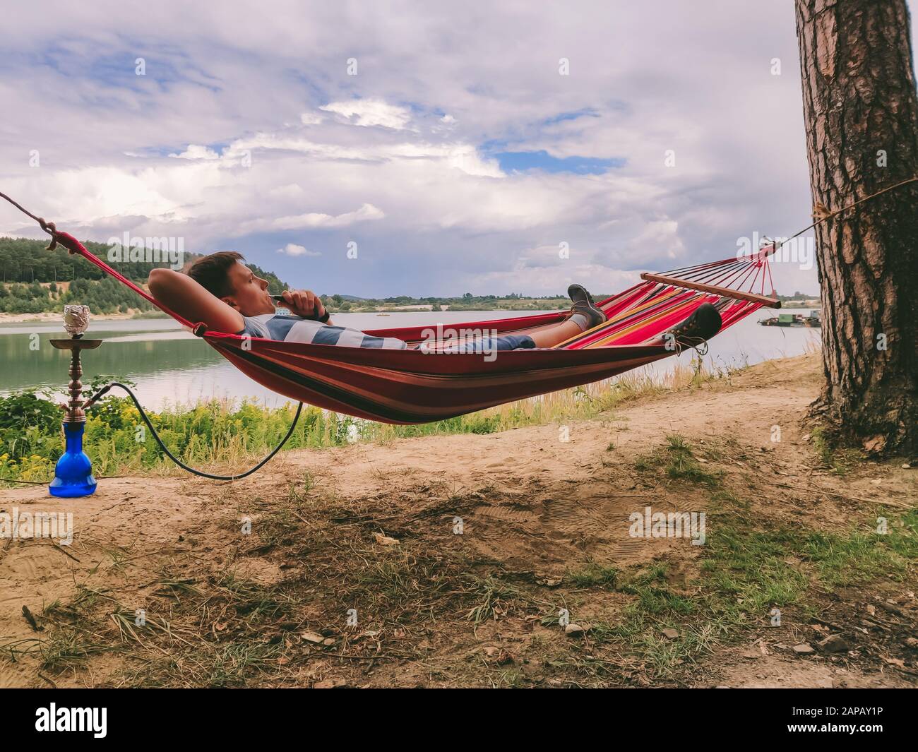 man laying at hammock smoking hookah looking at lake beach Stock Photo ...