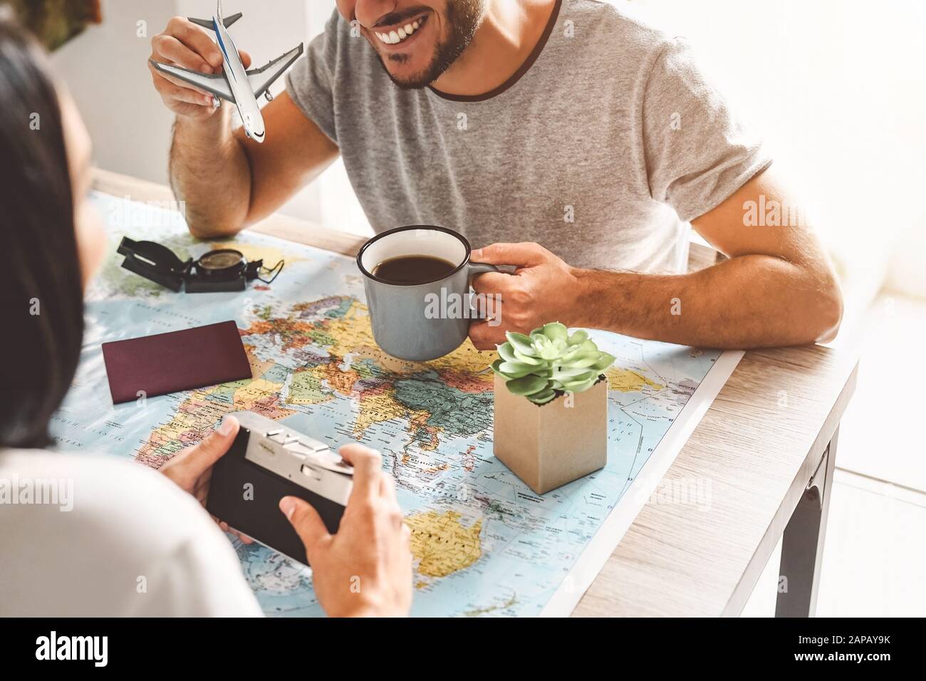 Happy couple planning next travel destination using world map - Young ...