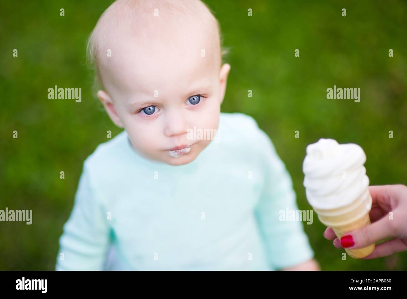 blue-eyed girl with traces of ice cream on her lips, in the frame the ...