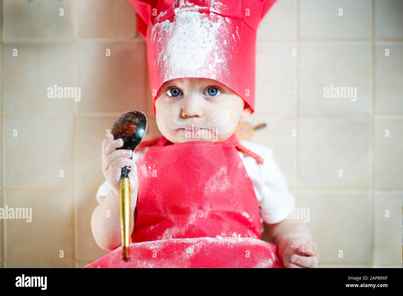 little girl in a cook suit soiled in flour, closeup Stock Photo - Alamy