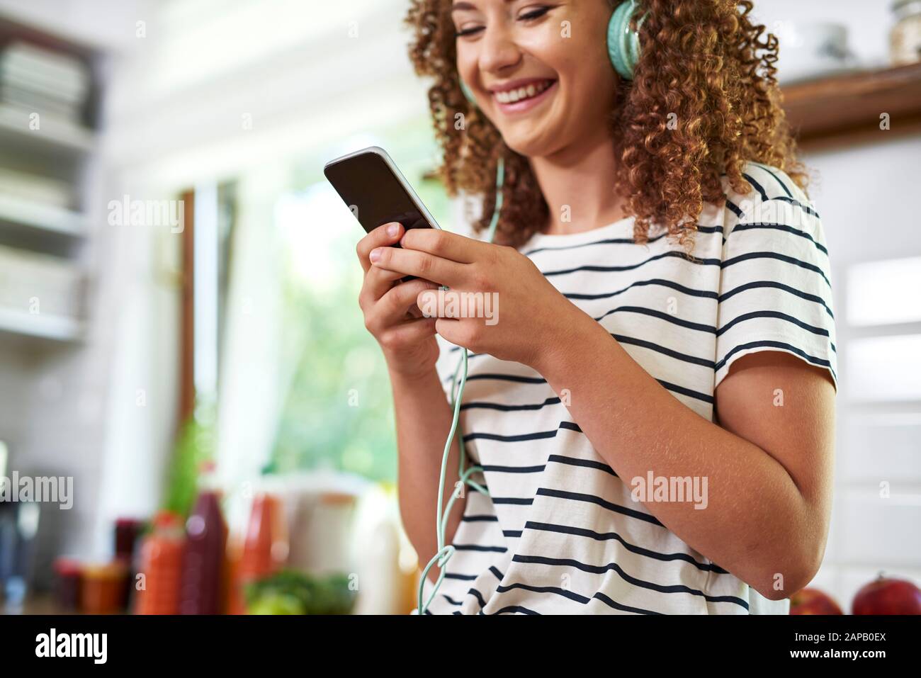 Woman using headphones and mobile phone Stock Photo - Alamy