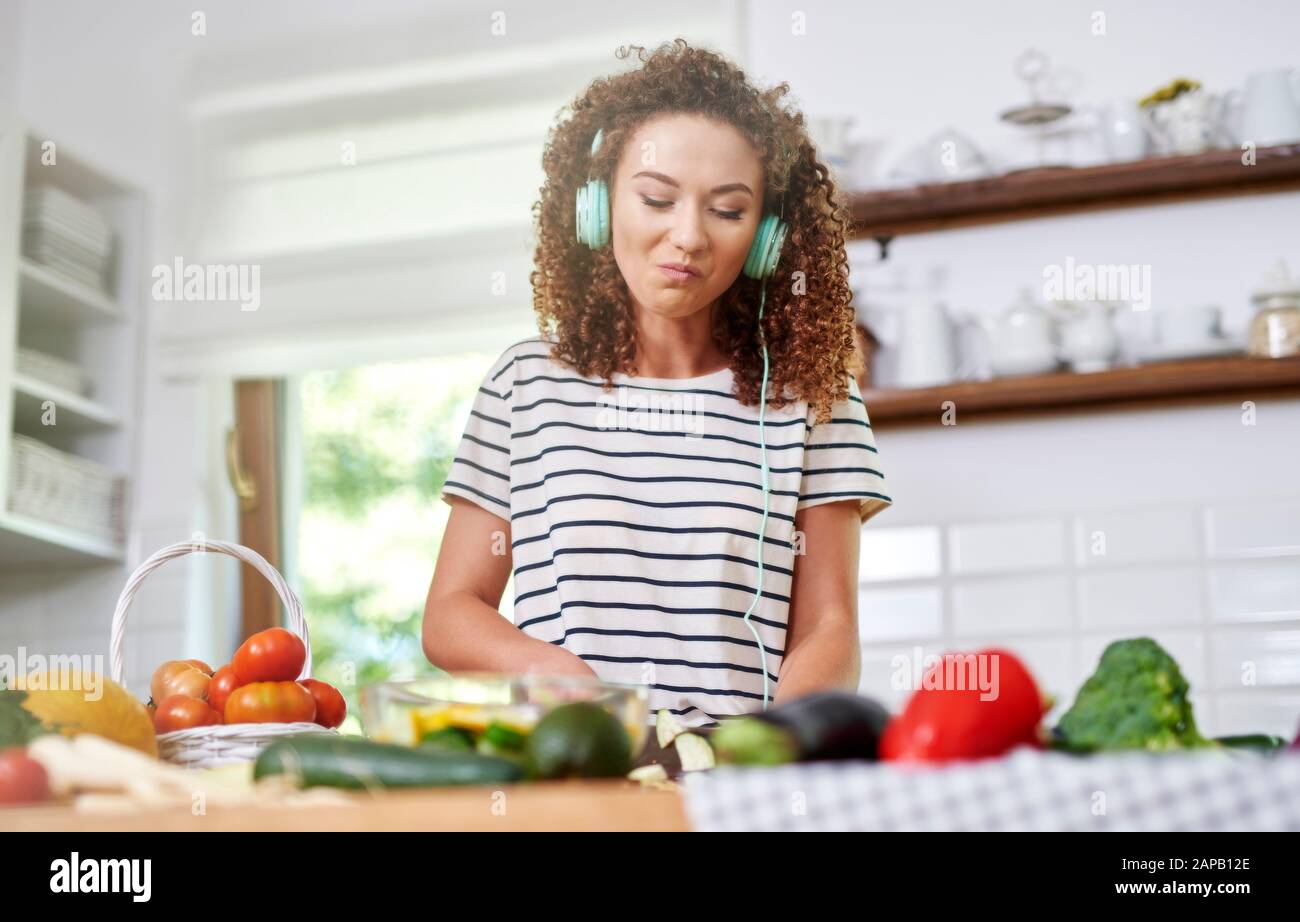 Woman cooking and listening music at once Stock Photo - Alamy
