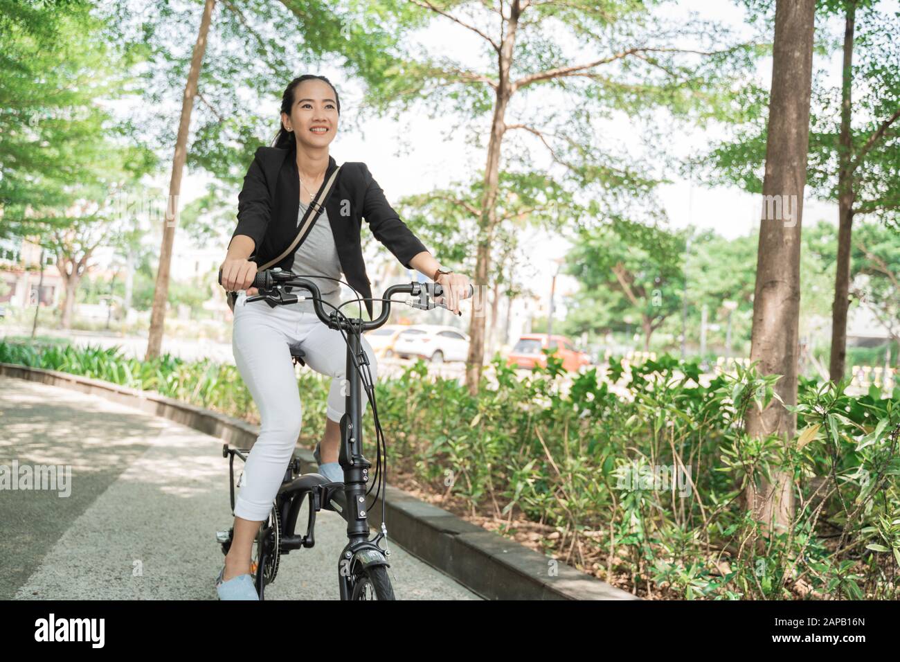 Smiling business woman riding her folding bike Stock Photo - Alamy