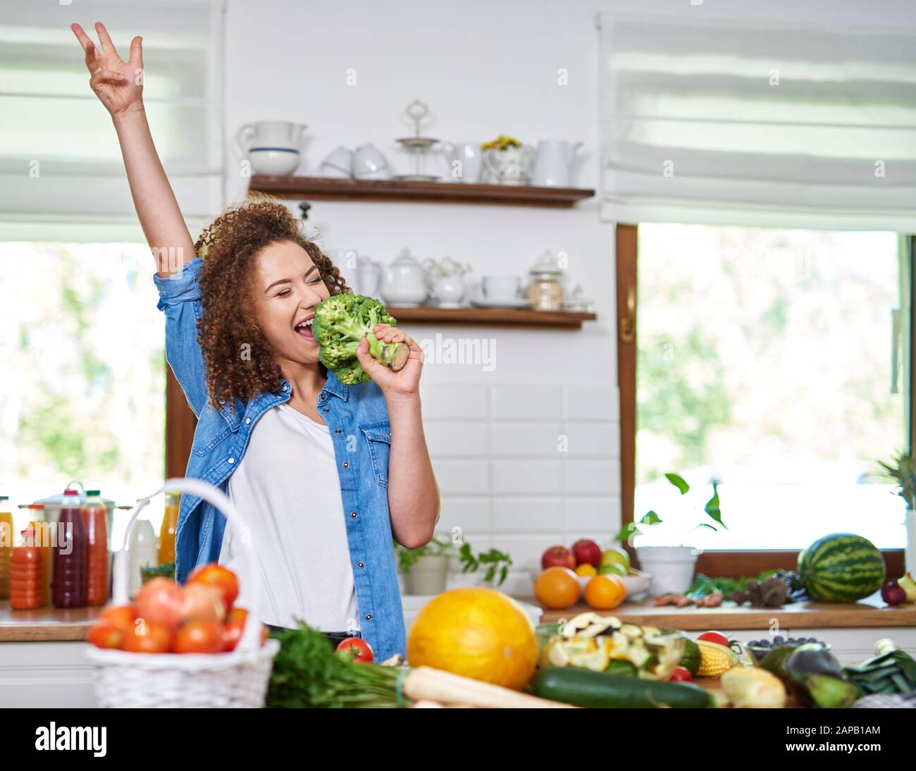 Happy woman singing while cooking a meal Stock Photo - Alamy