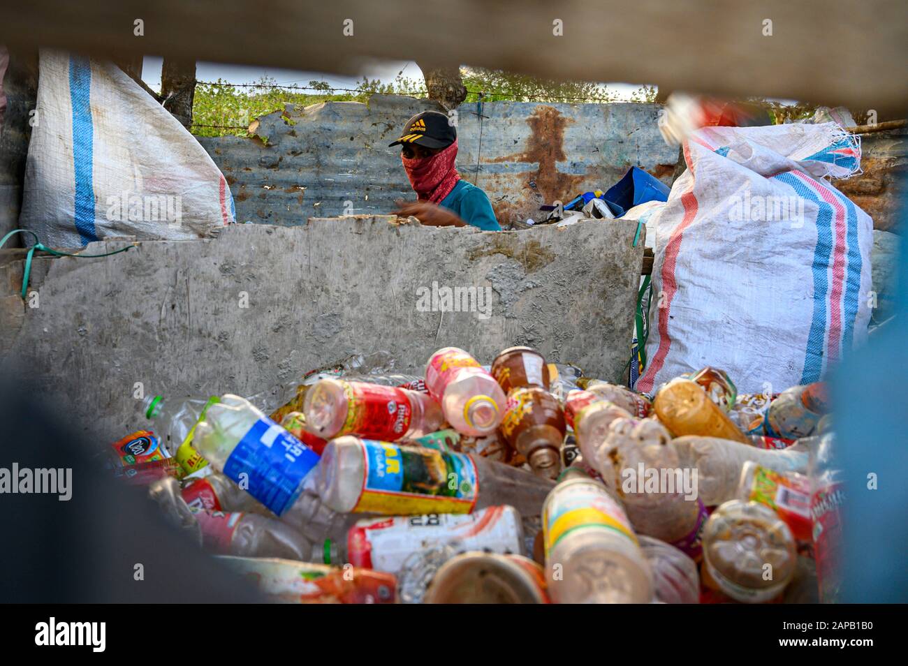 A scavenger sorts out the plastic waste he collects for recycling at ...