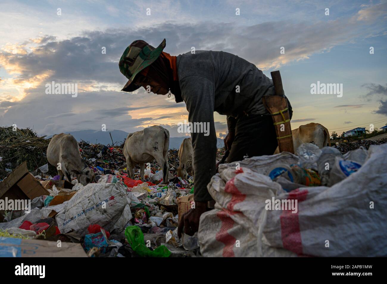 A scavenger picks up plastic waste to be recycled at the Kawatuna ...