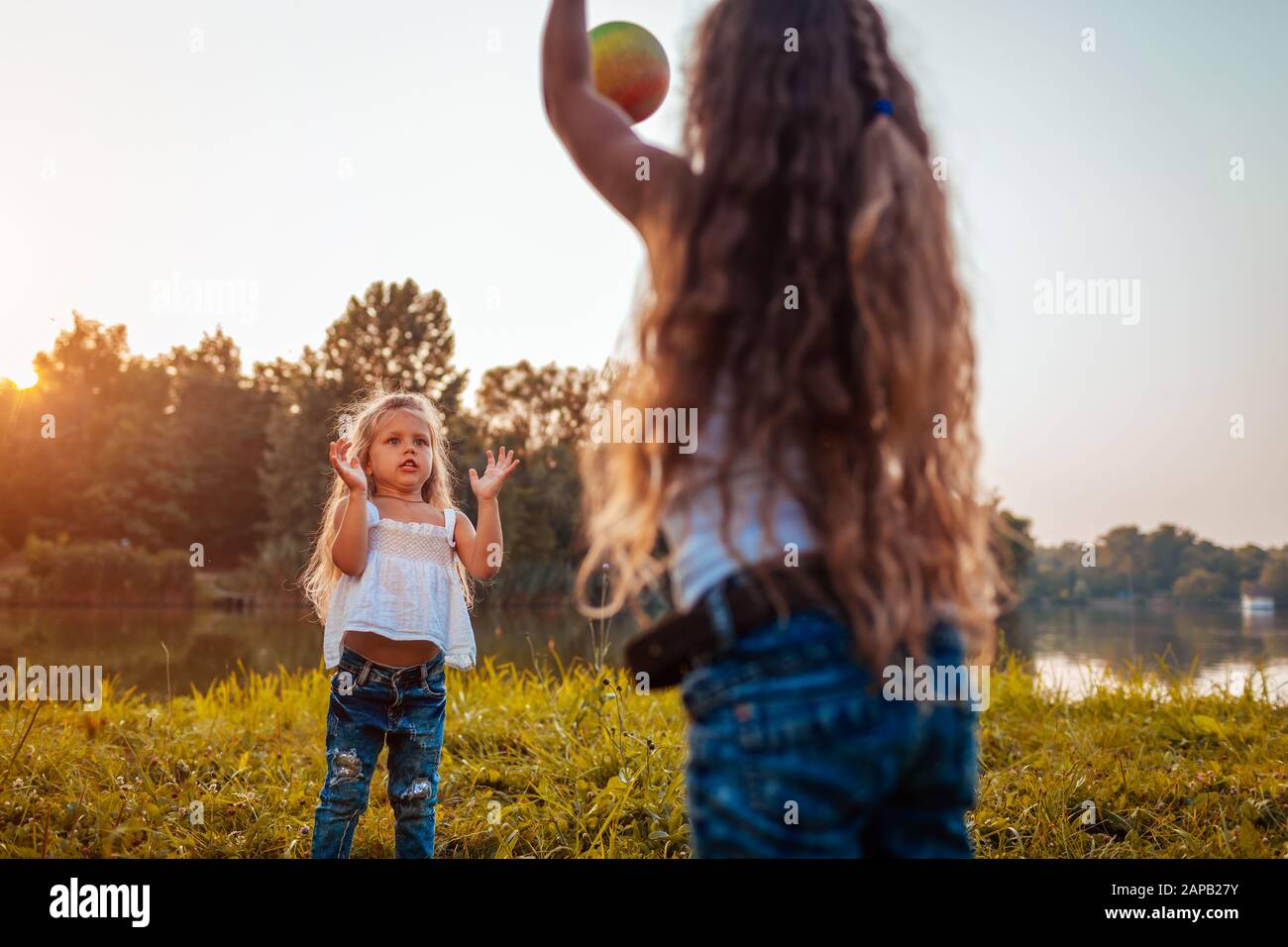 Little girls sisters playing with ball in summer park. Kids siblings ...
