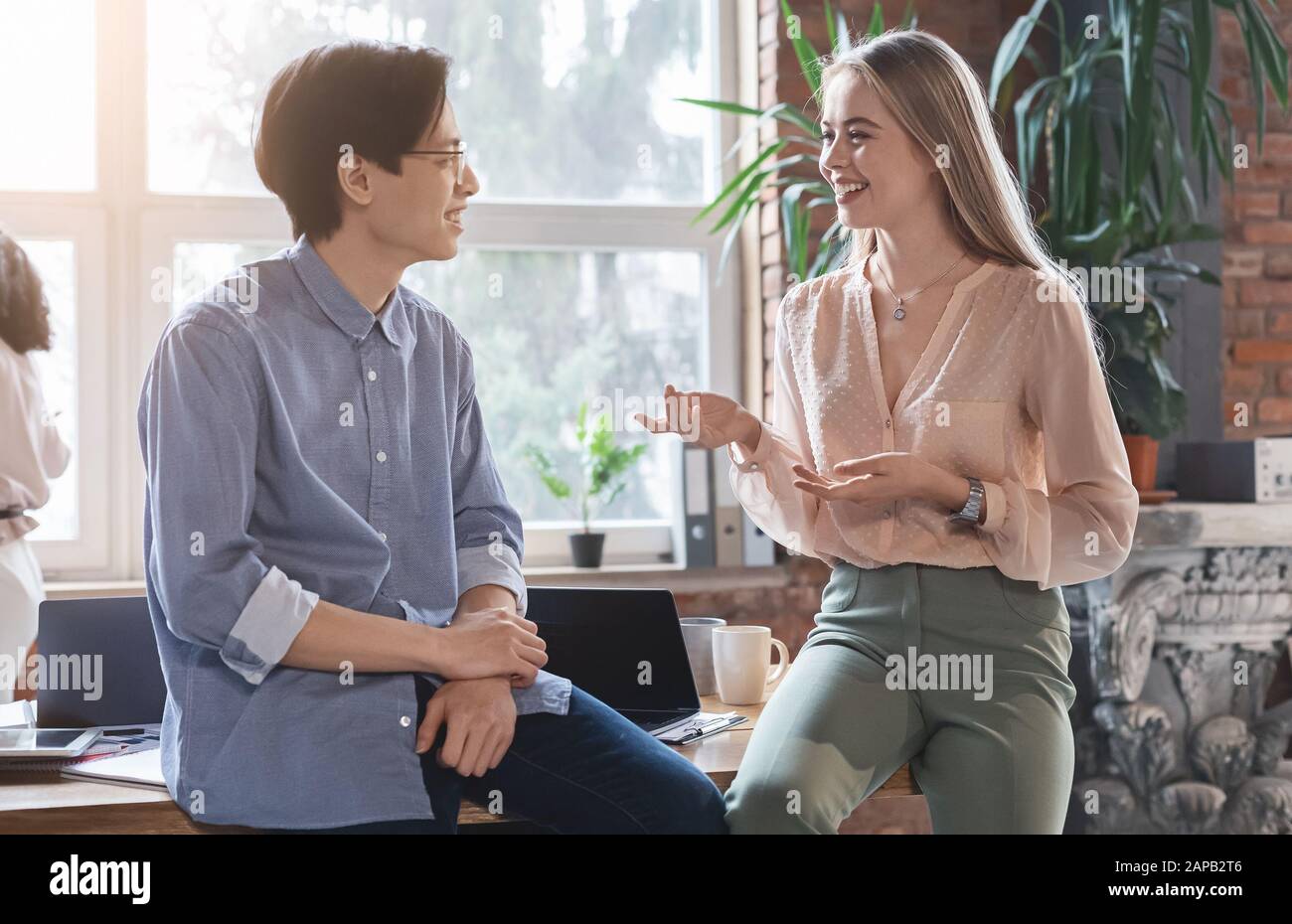 Asian guy and caucasian girl having conversation at workplace Stock ...