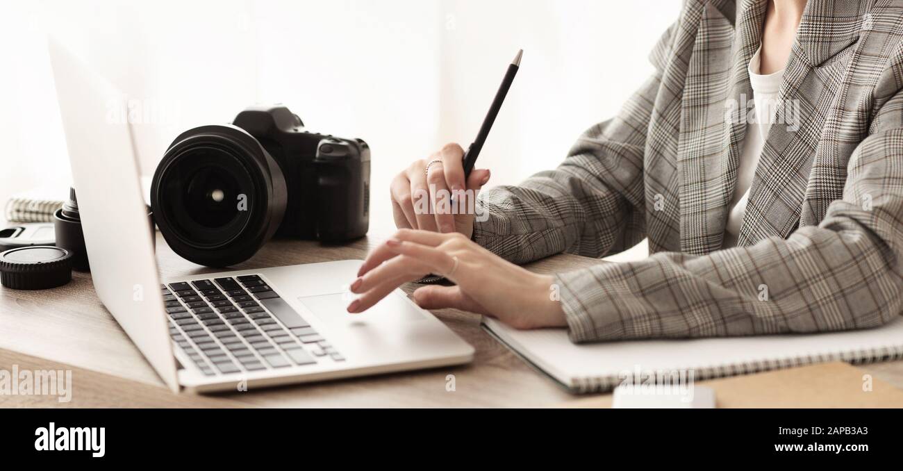 Female journalist working with laptop and camera Stock Photo - Alamy