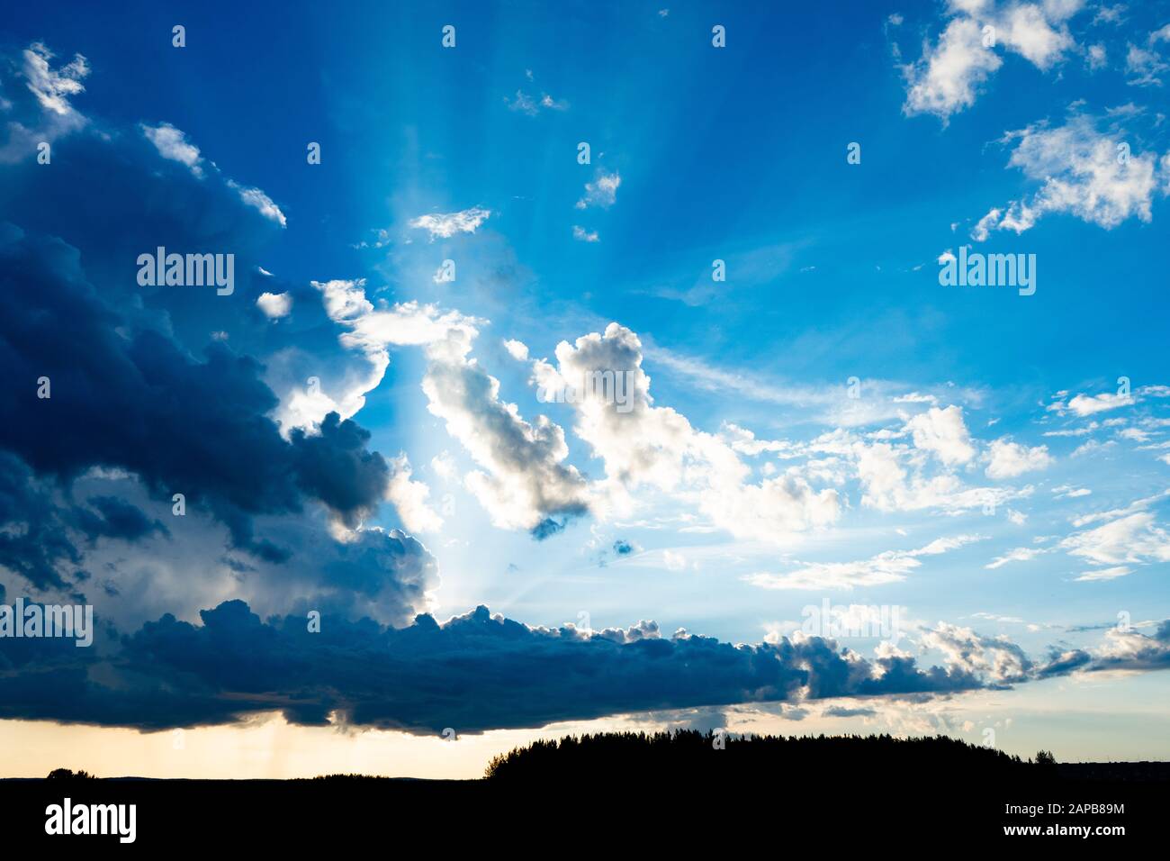 Rays of the sun through the clouds. Clouds and a blue sky with a ...