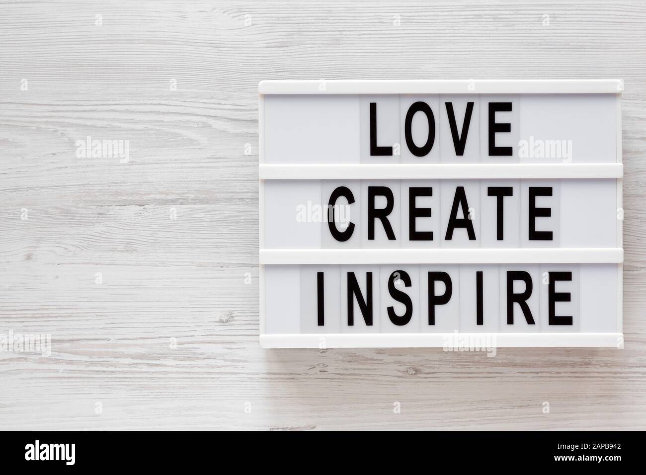 'Love create inspire' words on a modern board on a white wooden surface ...