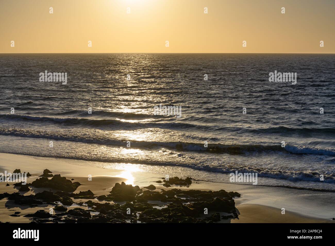 Sun rises over the ocean waves Stock Photo - Alamy