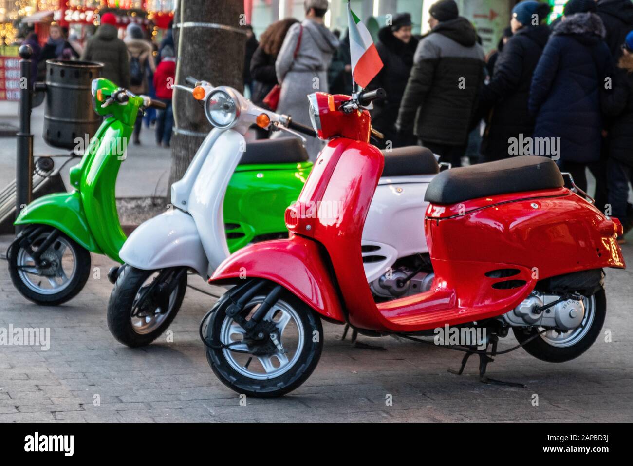 Three beautiful colored mopeds are parked on the street. Vehicle in the ...