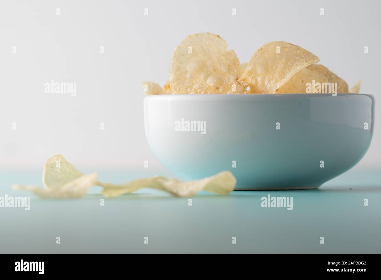 Potato chips heaping in a bowl Stock Photo - Alamy