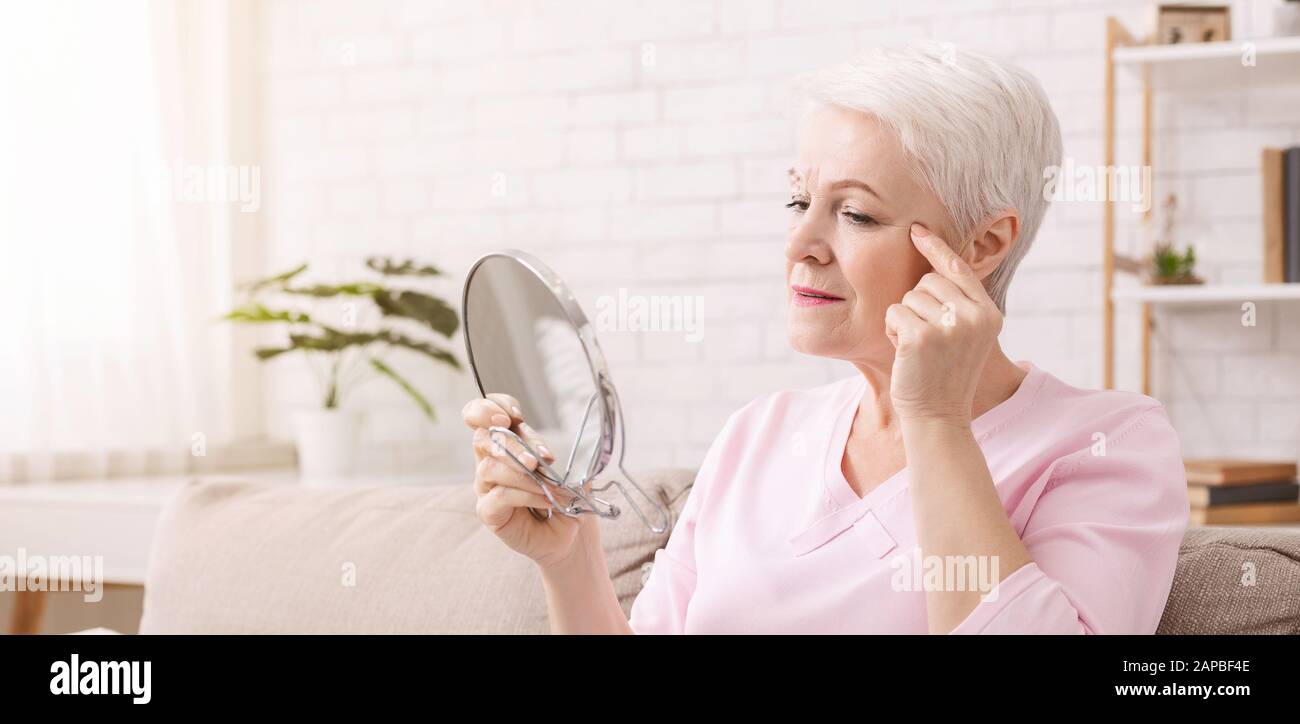 Mature woman examining skin hi-res stock photography and images - Alamy
