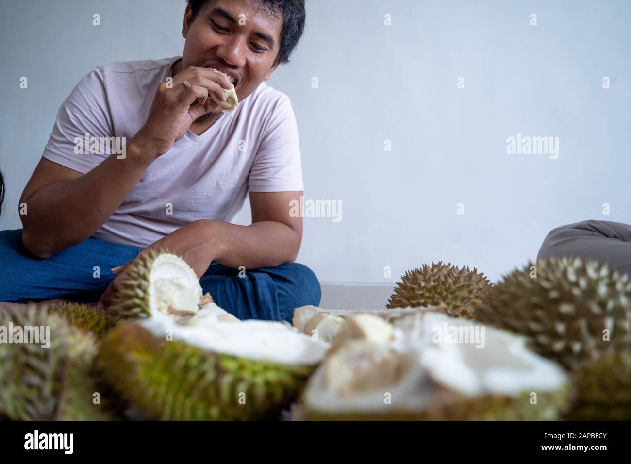 asian man enjoy eating durian fruit Stock Photo - Alamy