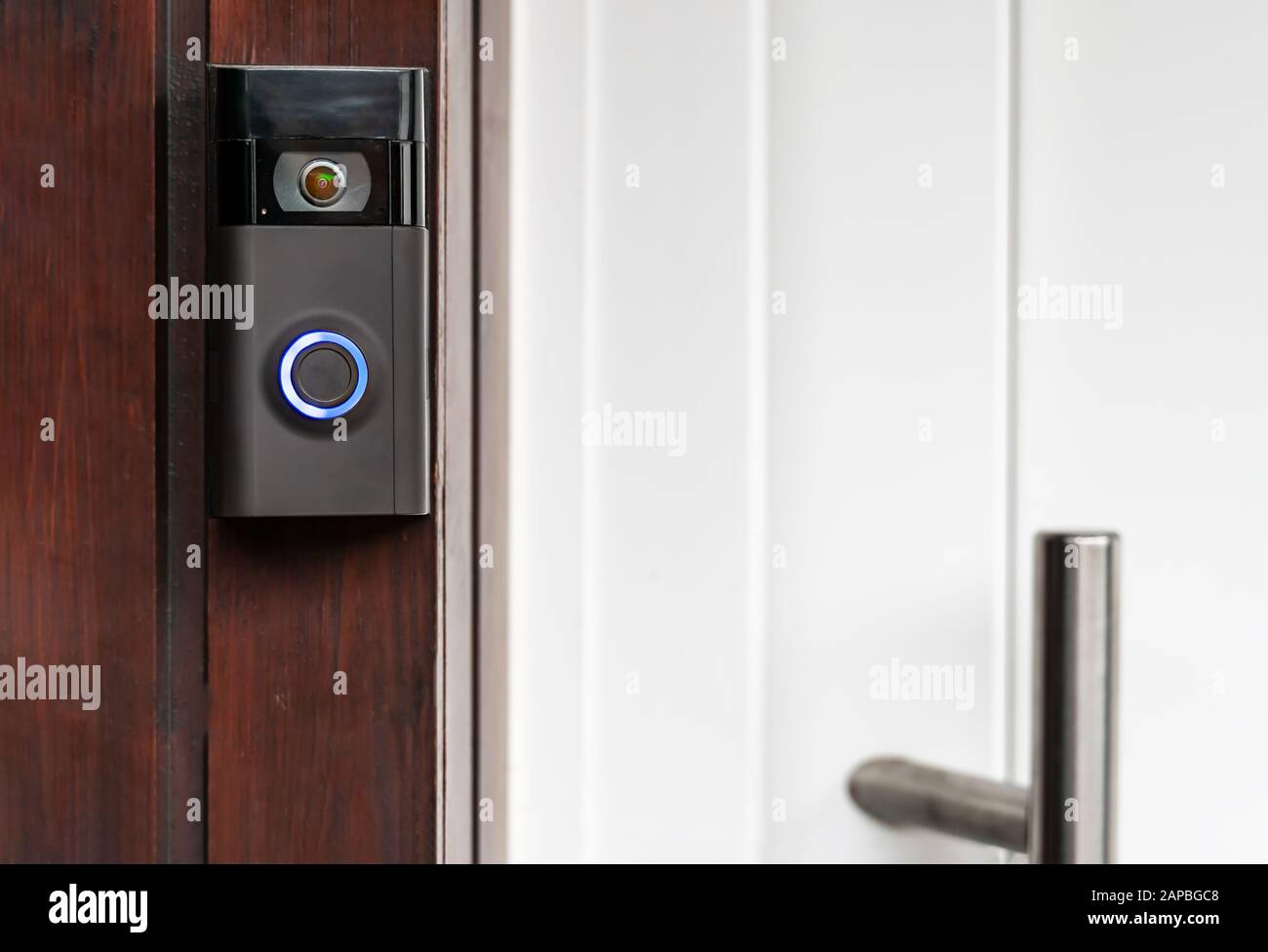 A modern surveillance camera is installed on a front door.A modern ...