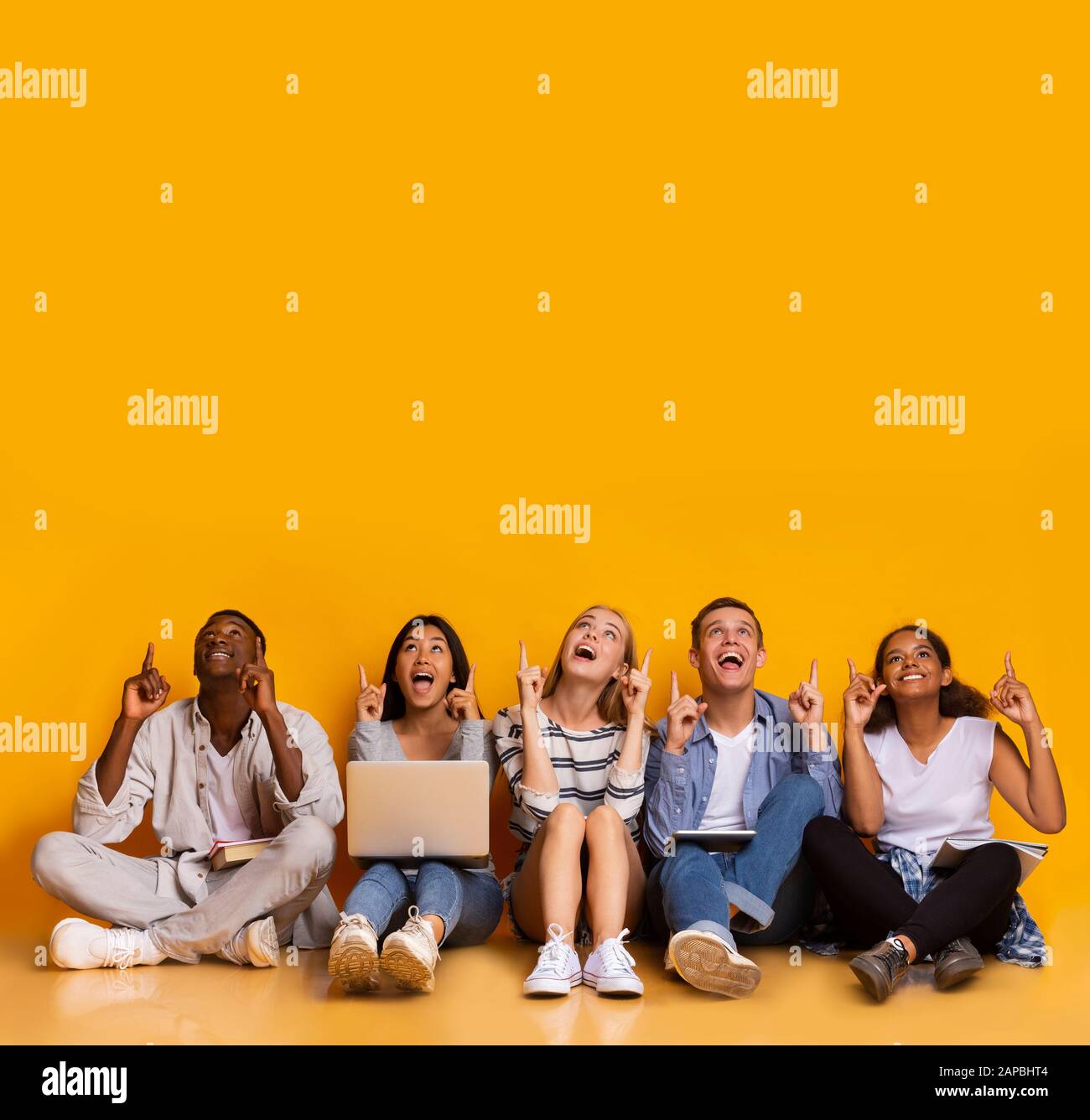 Excited multiracial students pointing up at copy space Stock Photo - Alamy