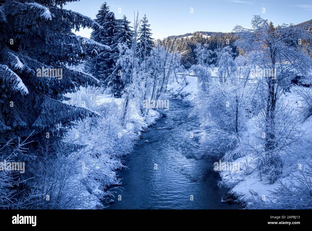 The cold waters of the stream flow in an outline of frozen trees Stock ...
