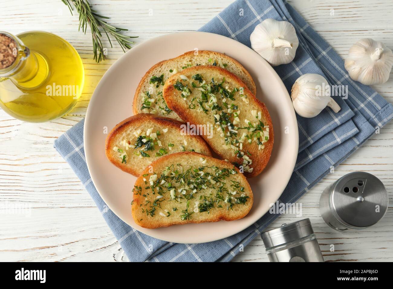 Plate with toasted garlic bread and oil on wooden background, top view ...