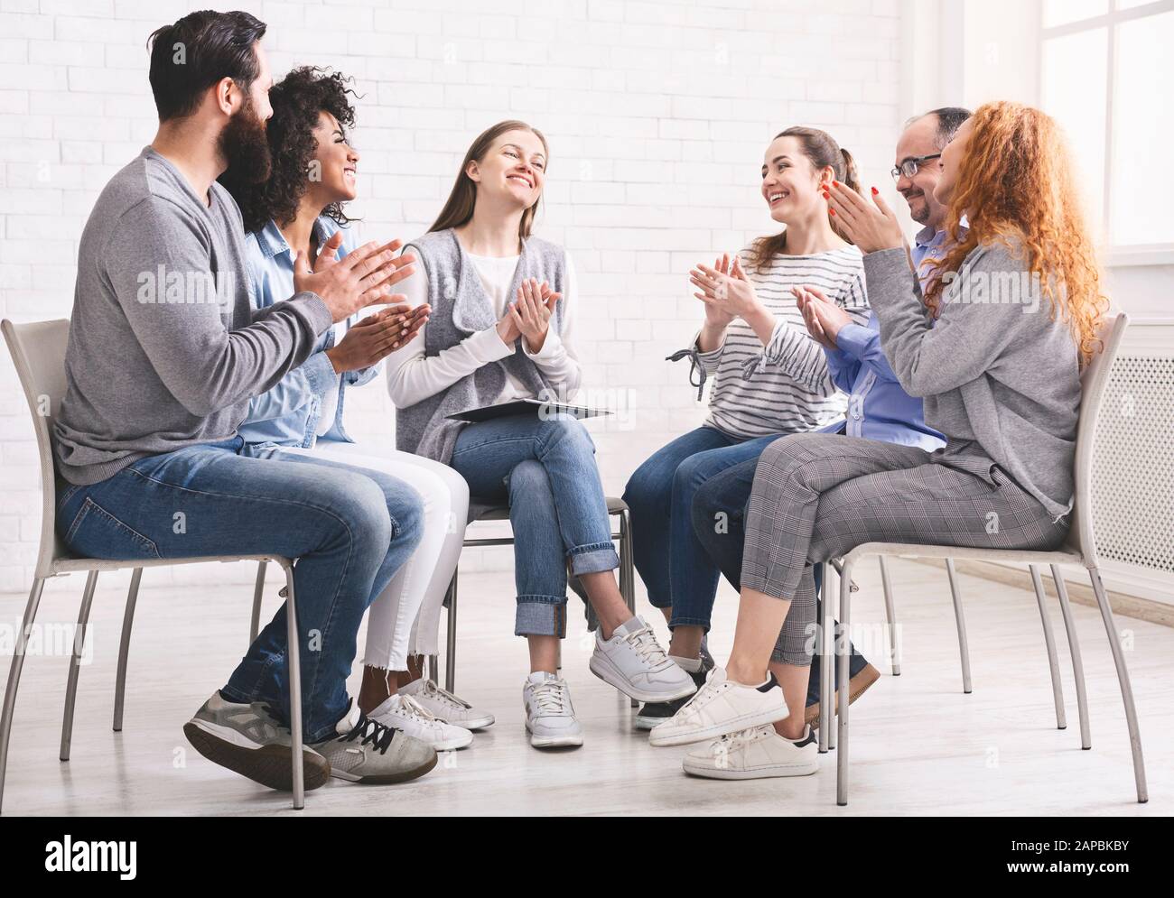 Group of happy people applauding themselves at therapy session ...