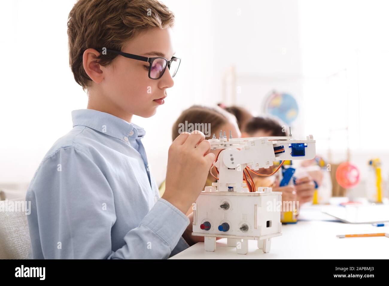 Schoolboy building and programming robot in computer coding class Stock ...