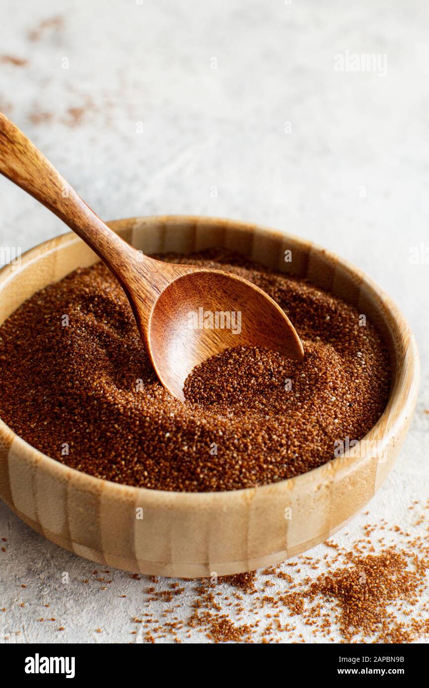 Uncooked teff grain in a bowl with a wooden spoon close up Stock Photo ...