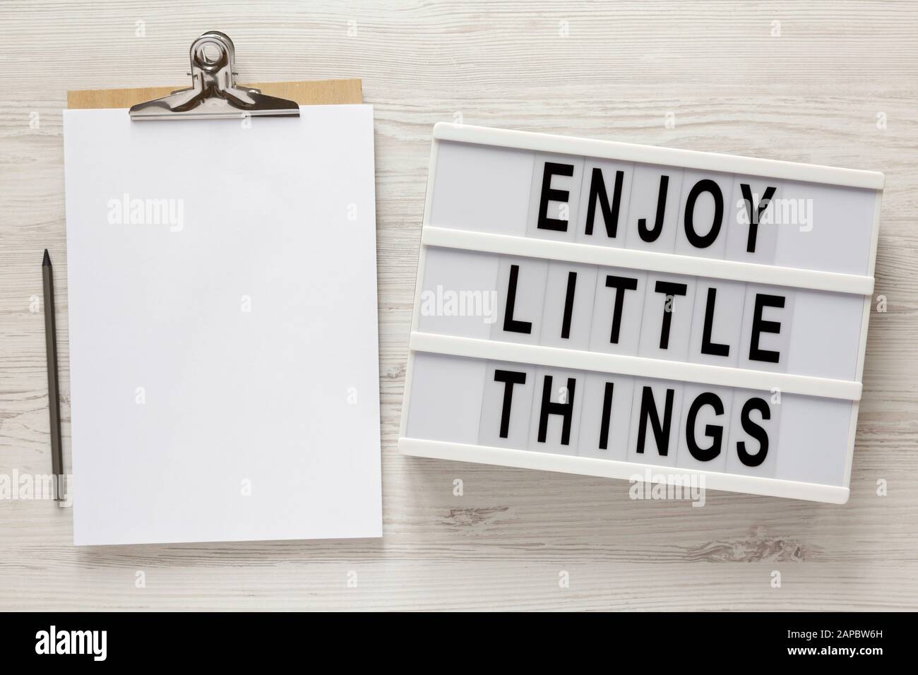 'Enjoy little things' words on a modern board, clipboard with blank ...