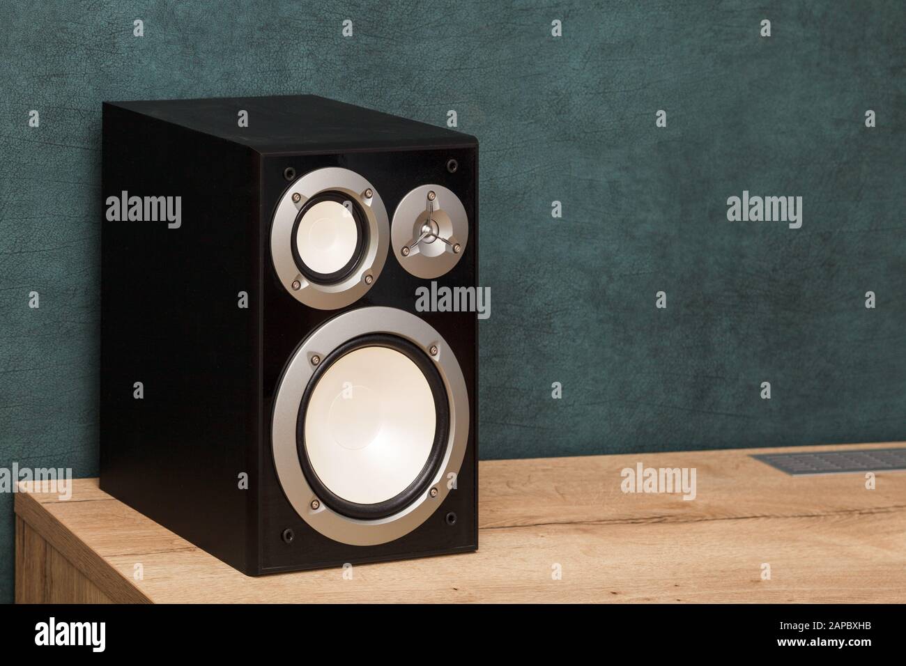 One modern black audio speaker system in interior on wooden desk near ...