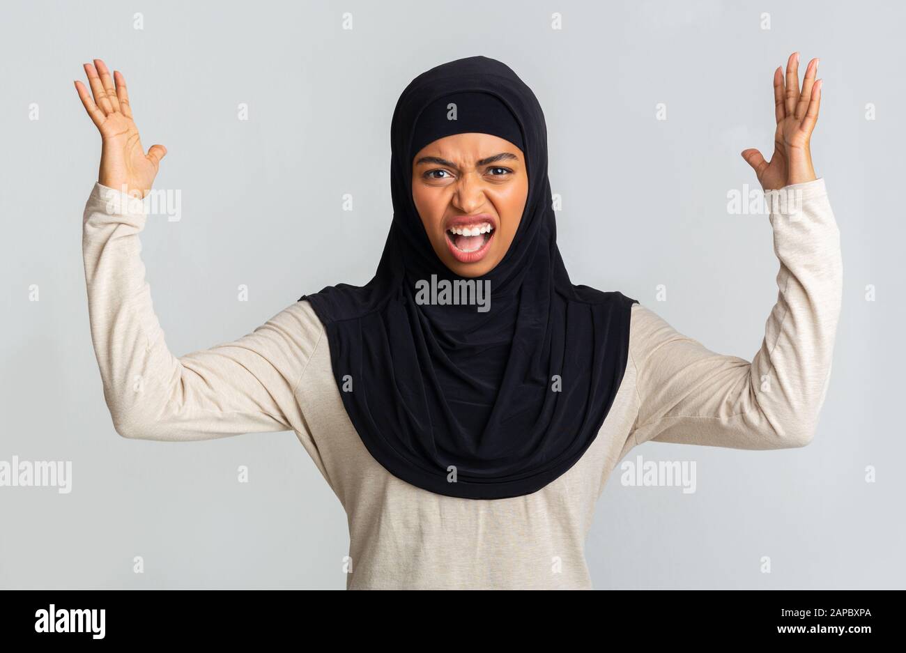 Angry black muslim girl shouting and raising hands in fury Stock Photo ...